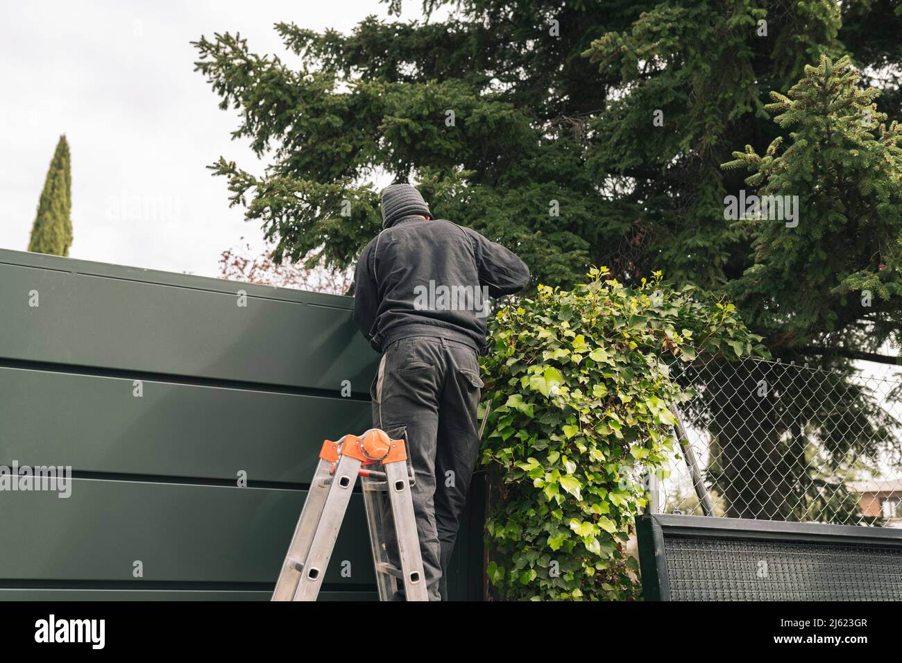 Construction worker standing on ladder working at construction site ...
