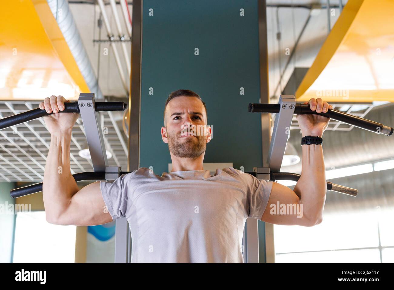 Young man doing workout with exercise machine in gym Stock Photo - Alamy