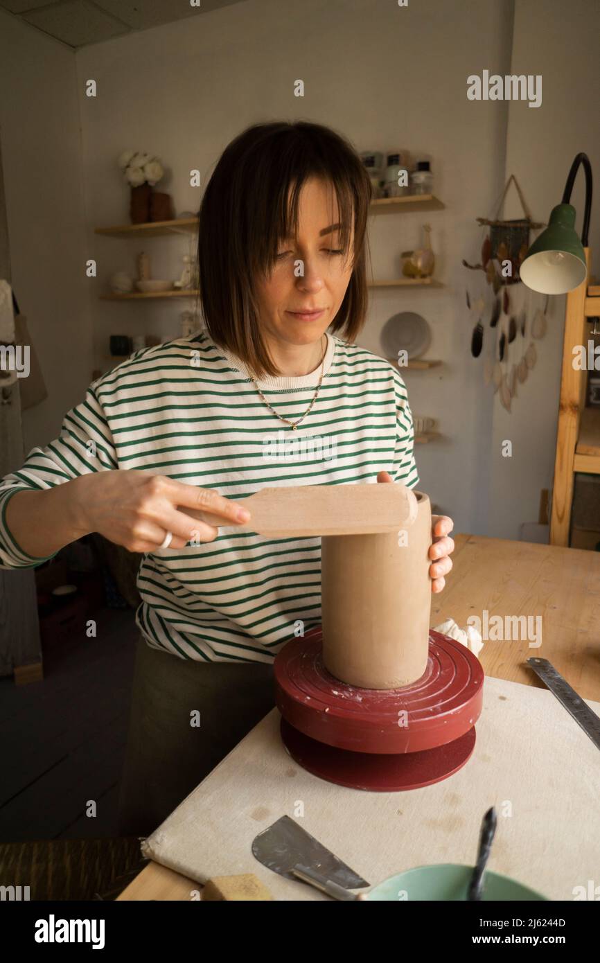 Craftsperson giving shape to clay pot at workshop Stock Photo - Alamy
