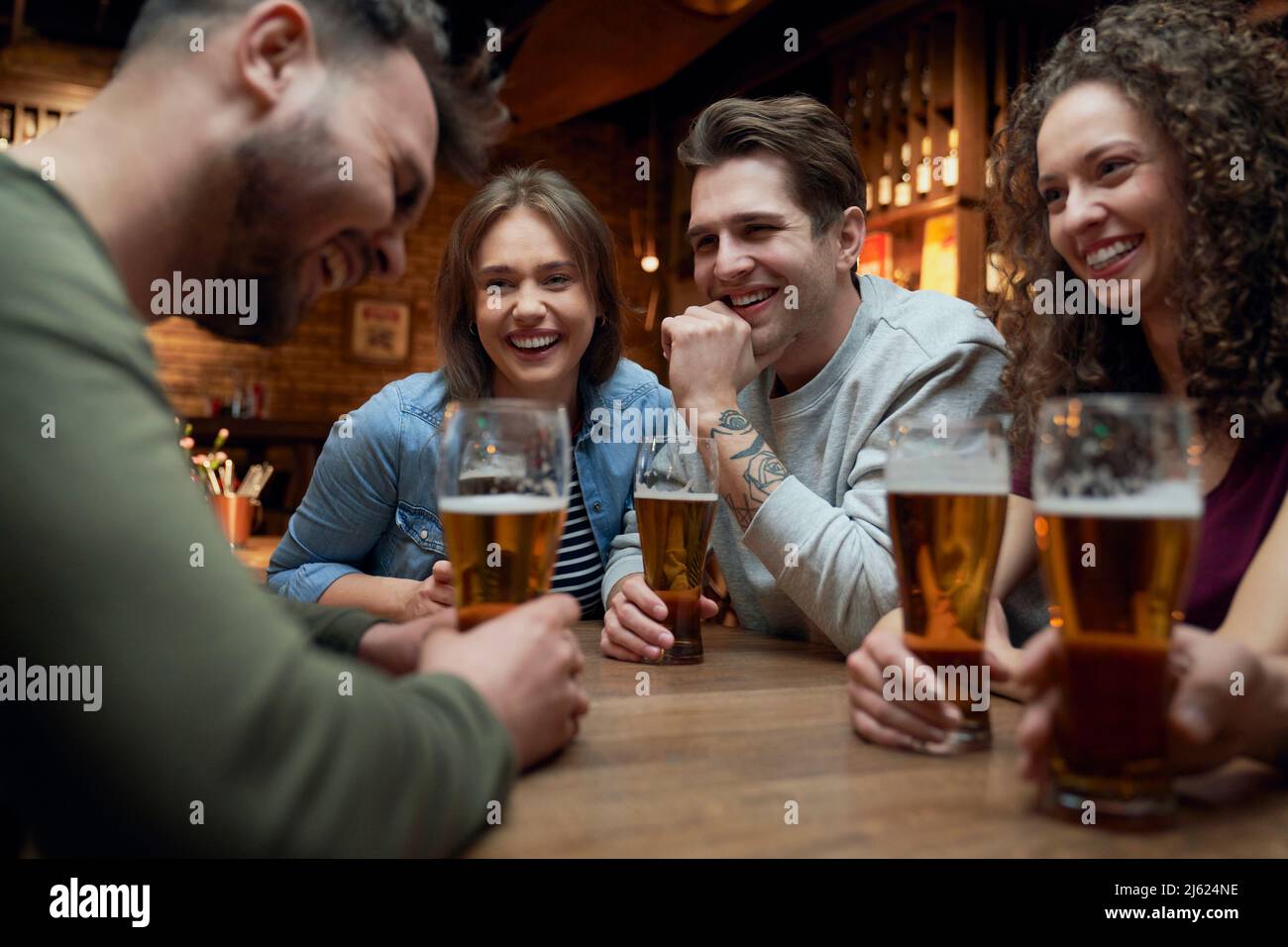 Group of happy friends having beer and socializing in a pub Stock Photo ...