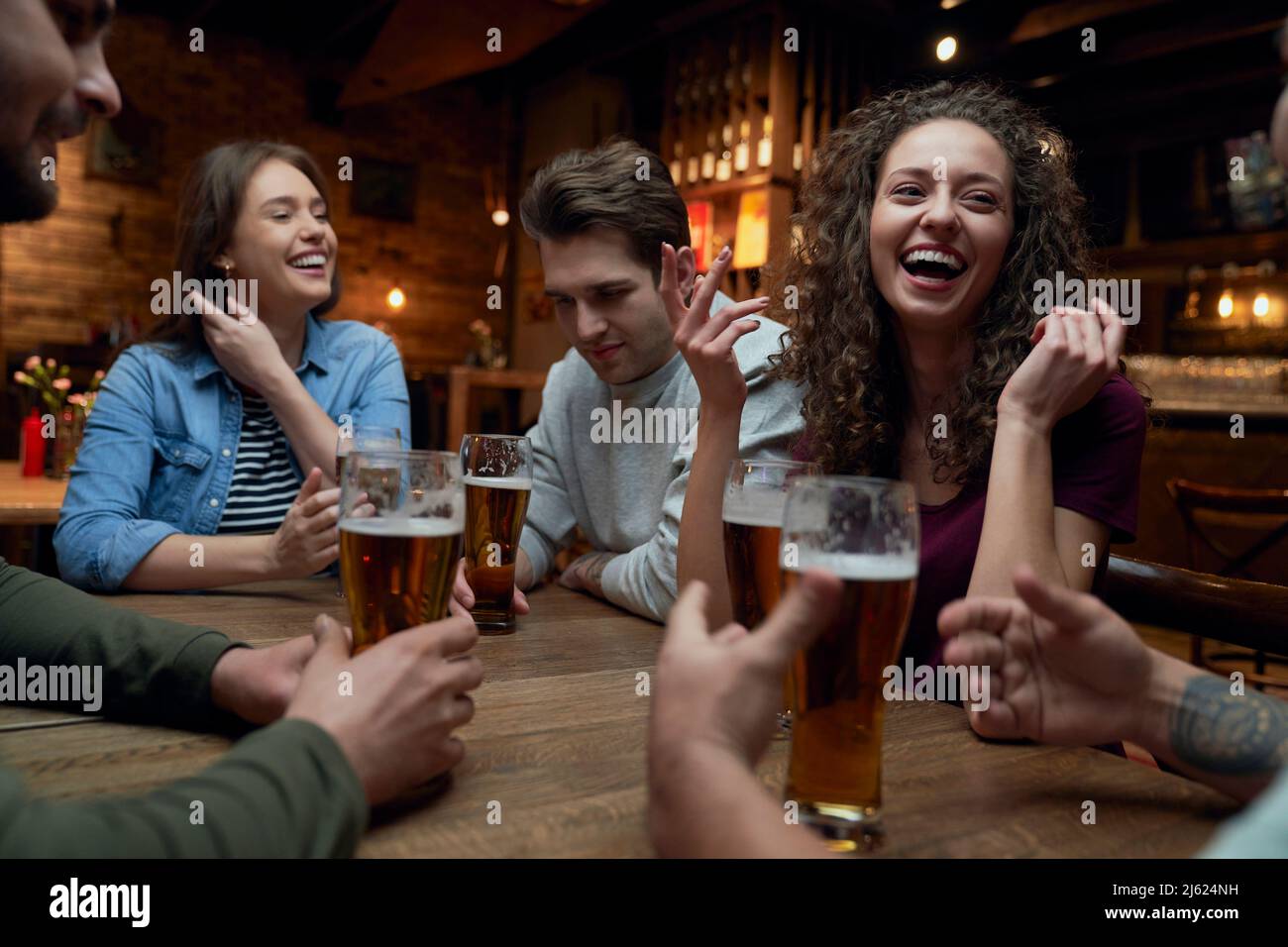 Group of happy friends having beer and socializing in a pub Stock Photo ...