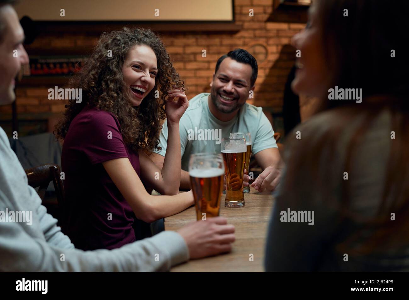 Group of happy friends having beer and socializing in a pub Stock Photo ...