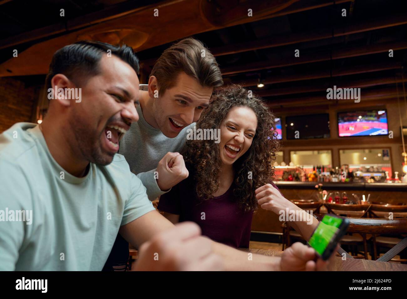 Cheerful soccer fans watching a match on smartphone in a pub Stock ...
