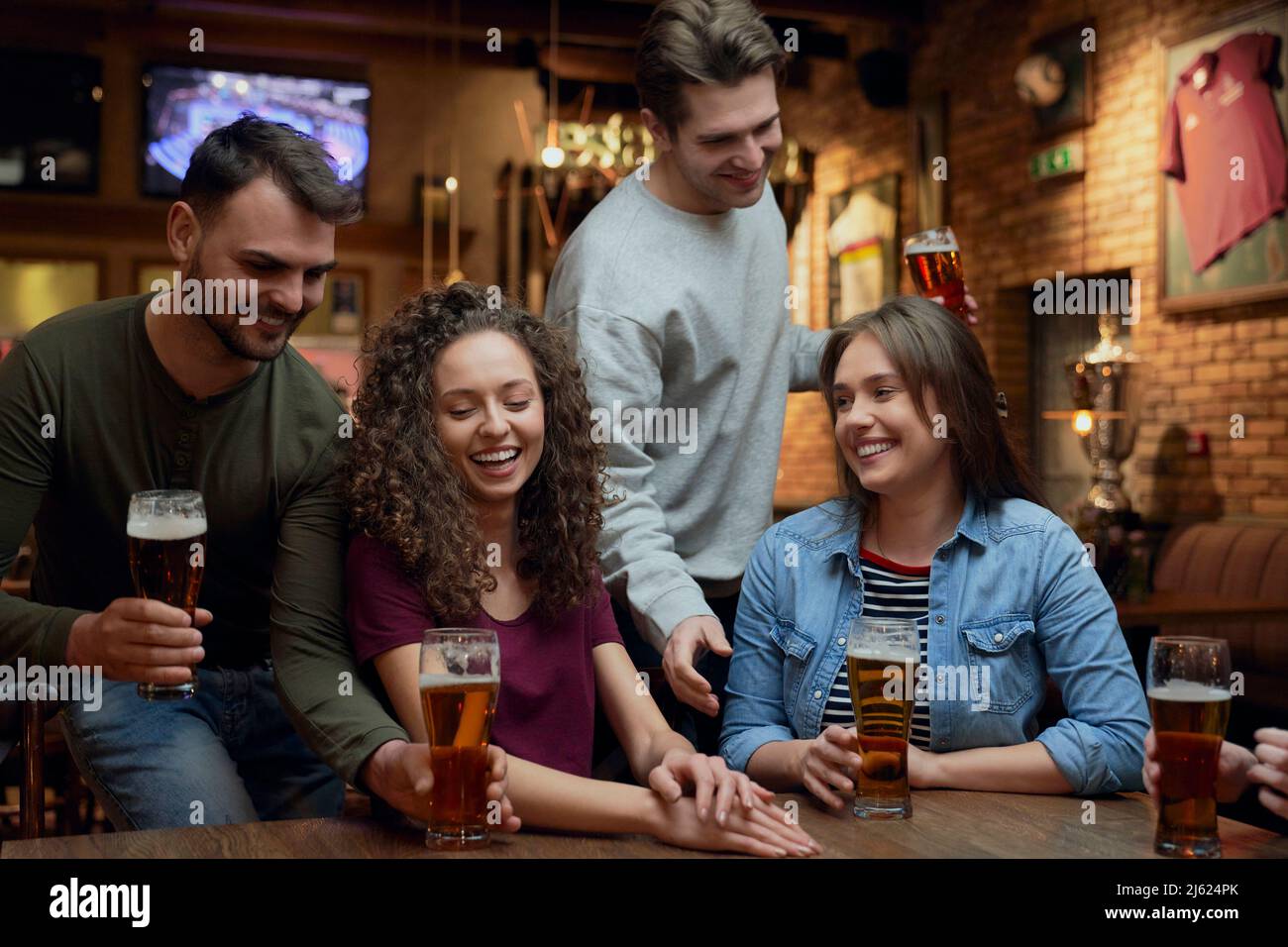 Smiling friends having beer in a pub Stock Photo - Alamy