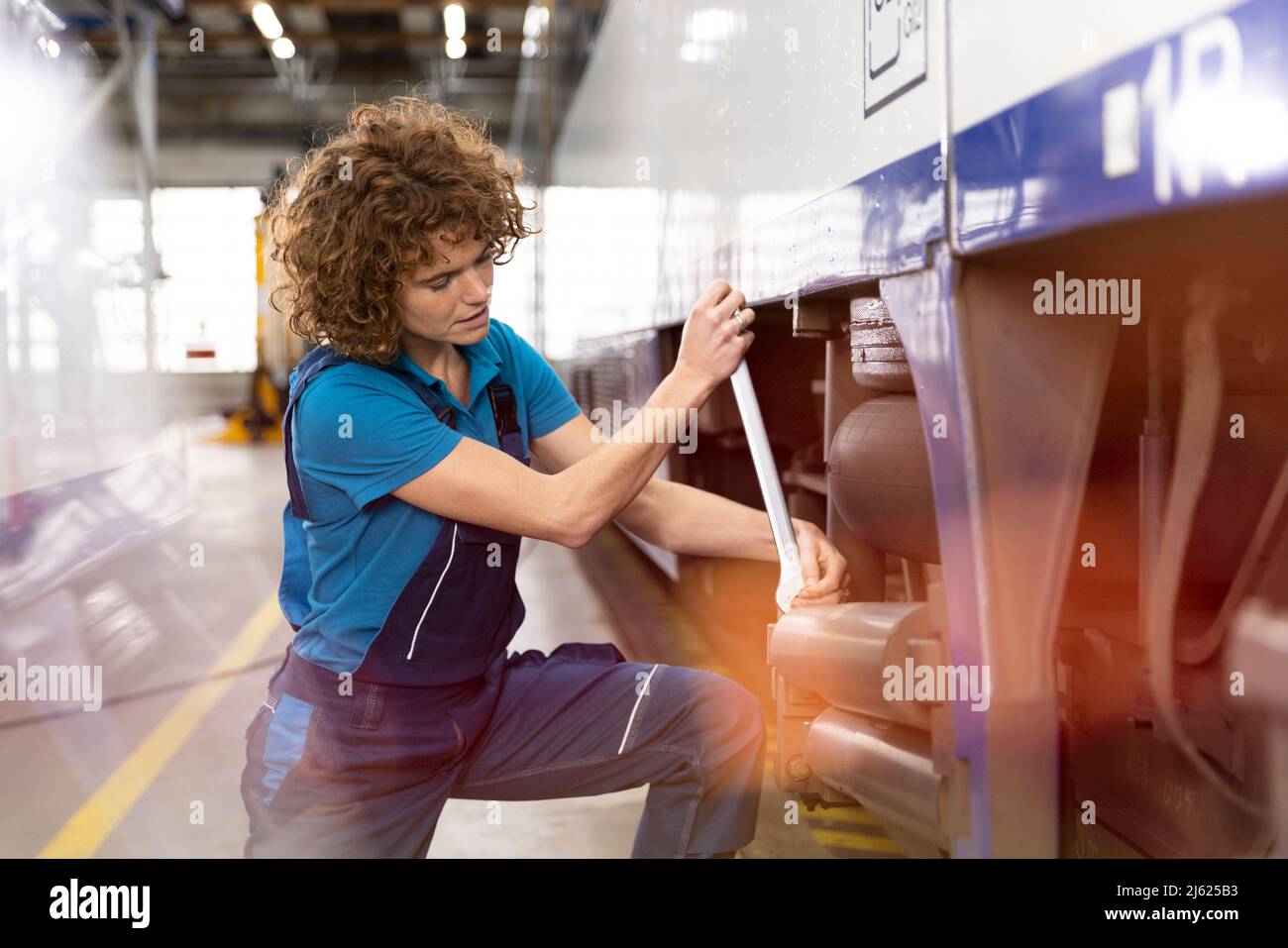 Engineer fixing monorail engine with wrench at industry Stock Photo - Alamy