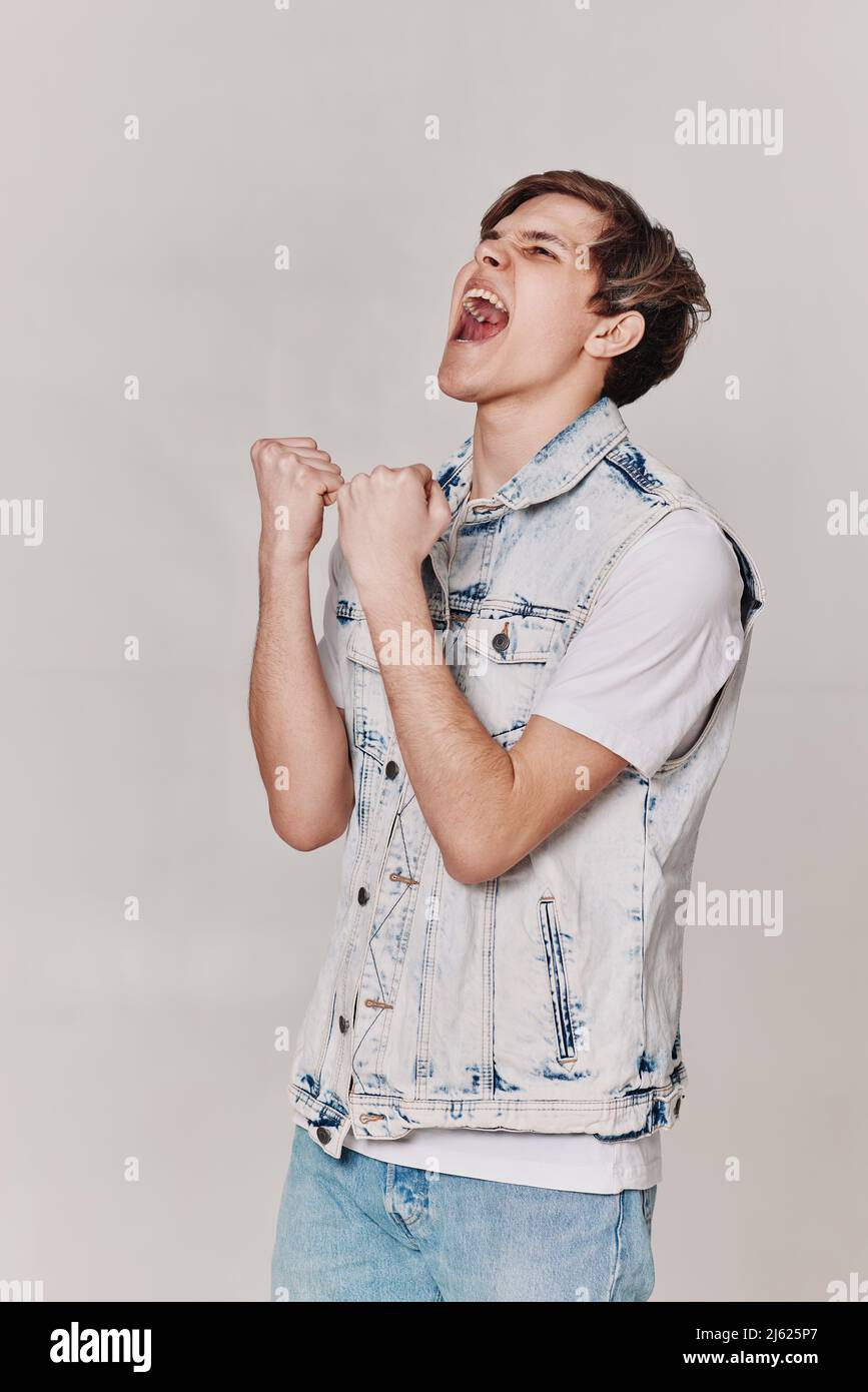 handsome man in denim showing victory gesture Stock Photo - Alamy