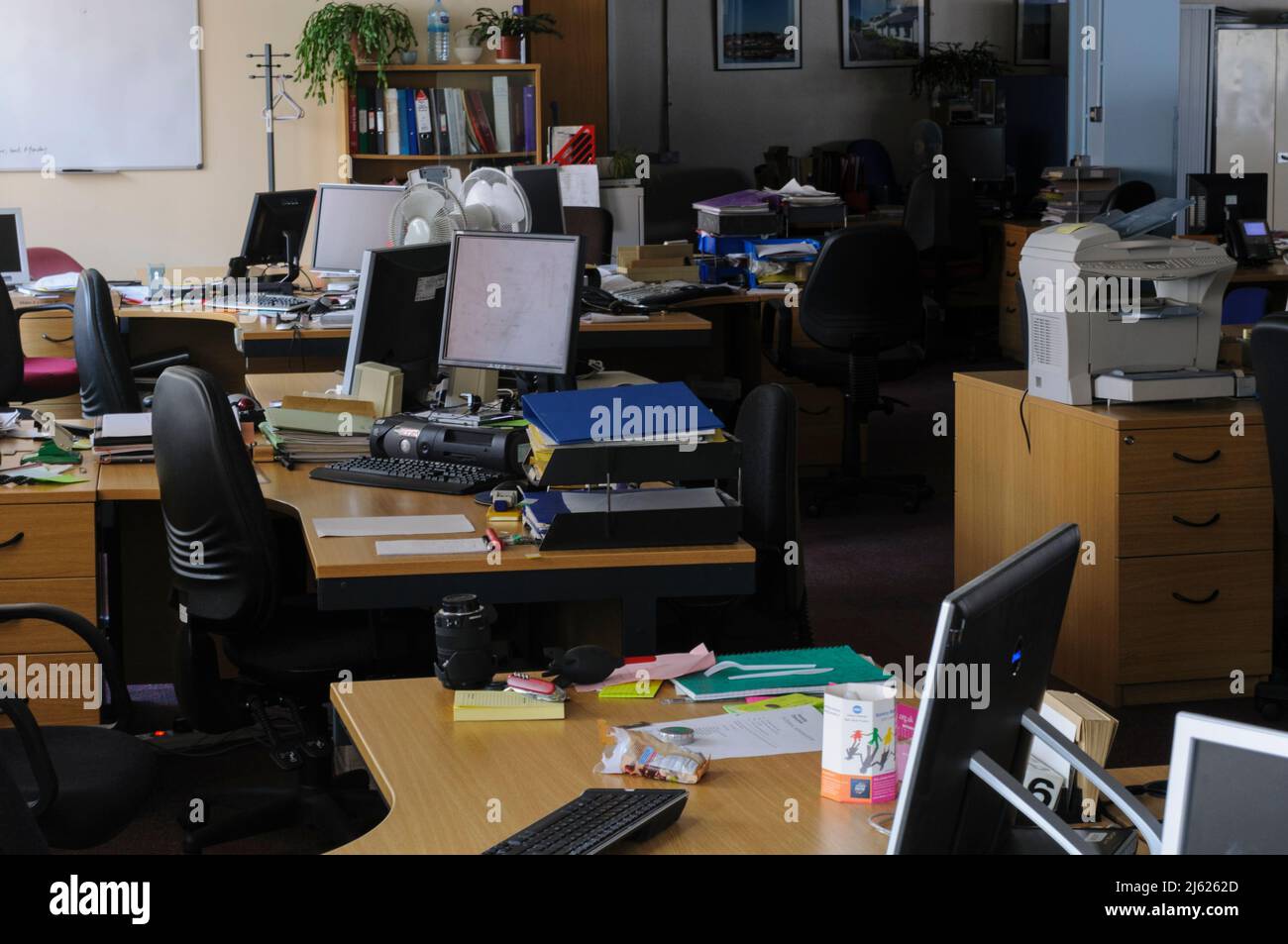 Empty desks in a dark office with all equipment and lighting turned off ...