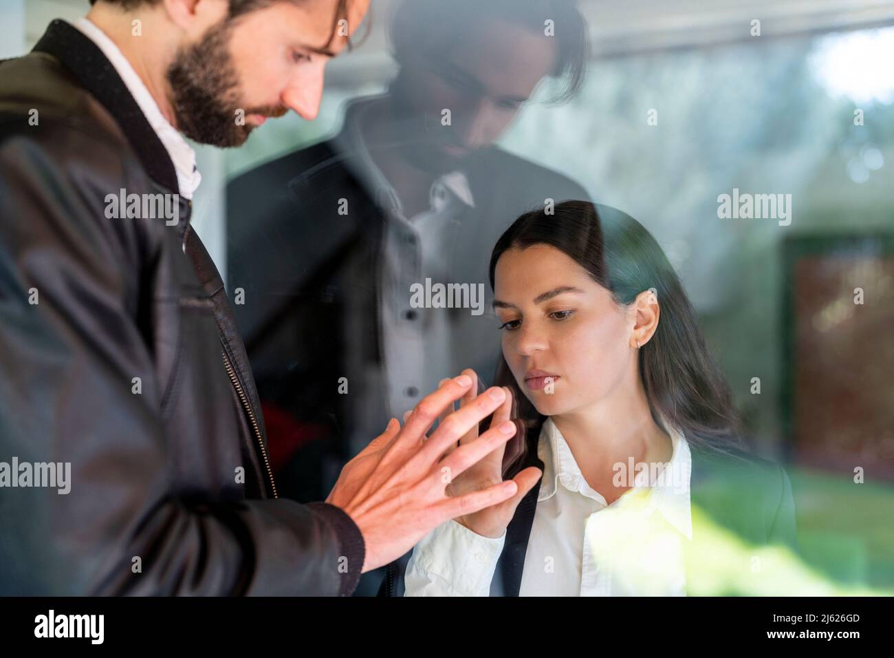 Yearning couple separated through glass pane Stock Photo - Alamy