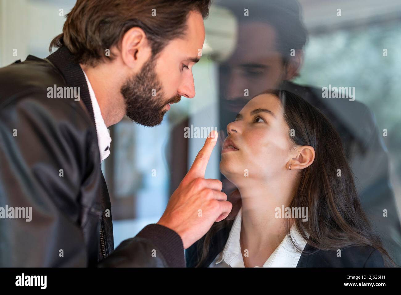 Yearning couple separated through glass pane Stock Photo - Alamy