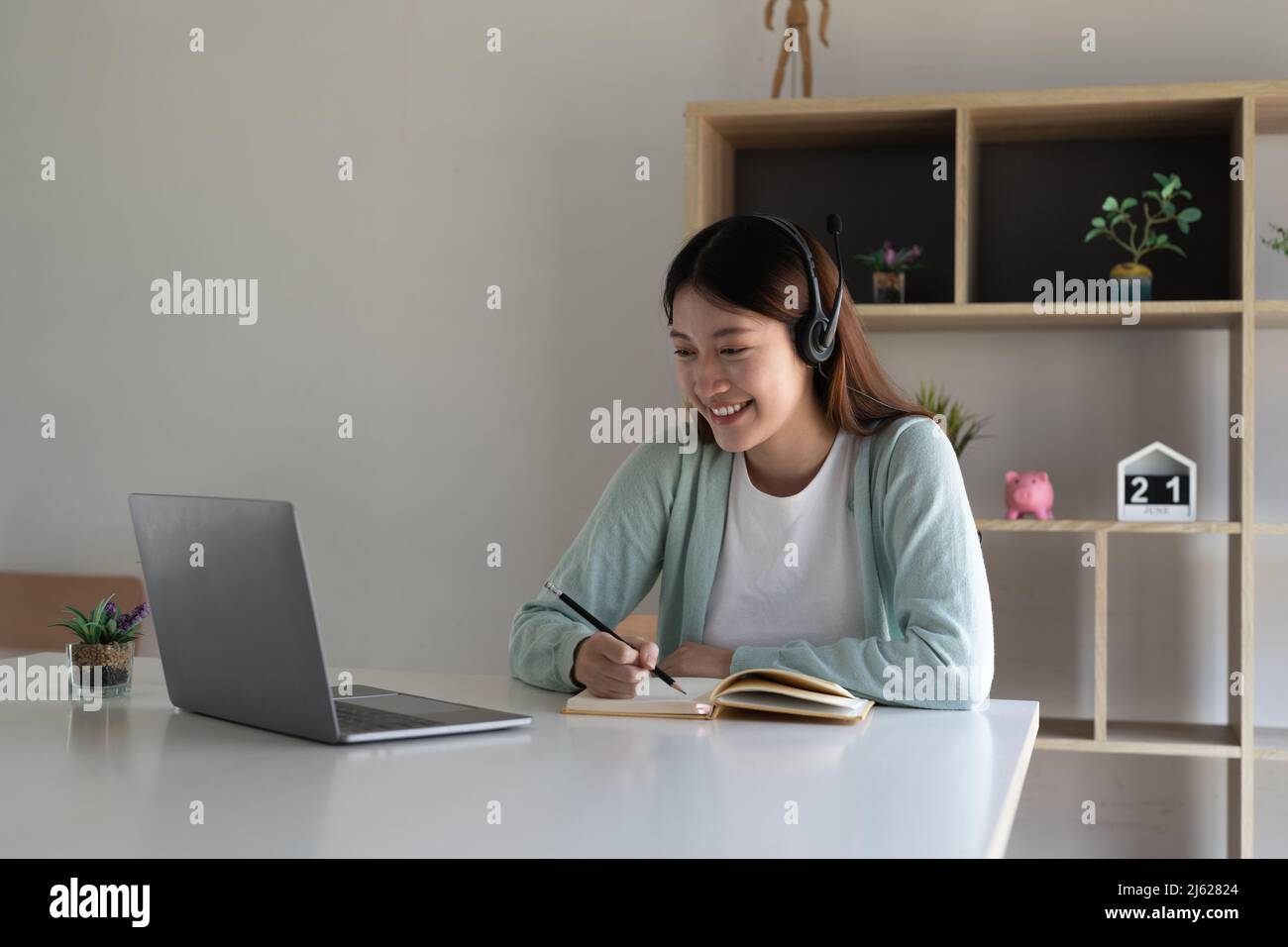 Young asian woman writing making list taking notes in notepad working ...