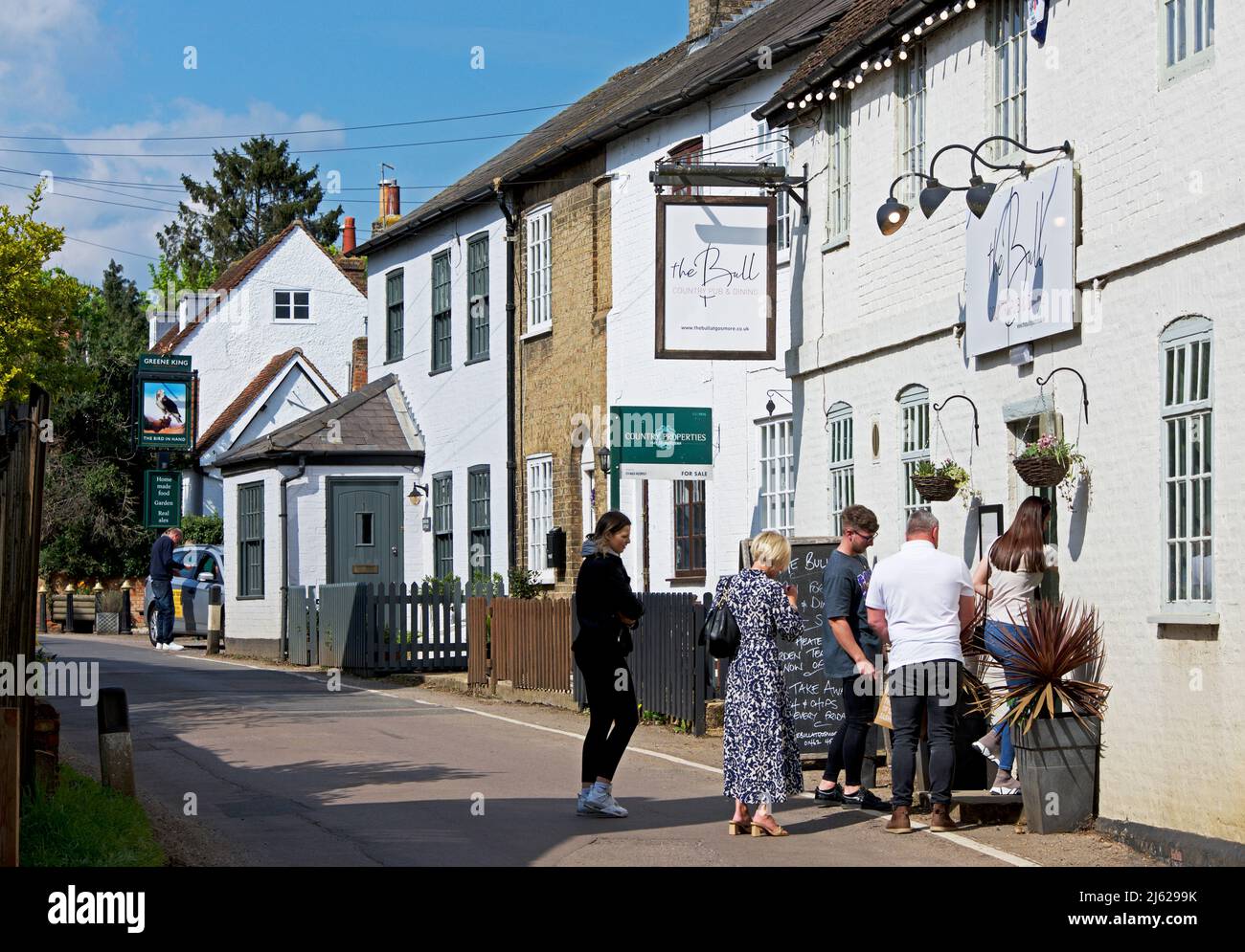 Group of people walking into the Bull pub in the village of Gosmore ...