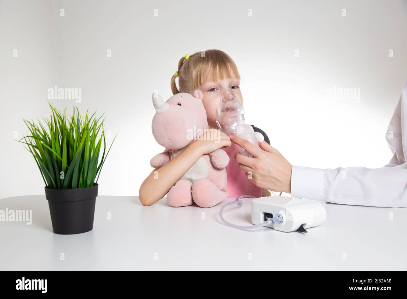 A 5-year-old girl is breathing into an inhaler at home. Treatment of ...