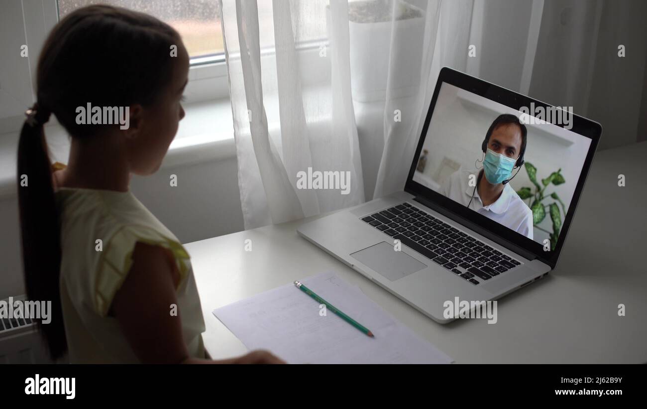 Pretty primary school girl distance learning at home. Focused cute kid ...