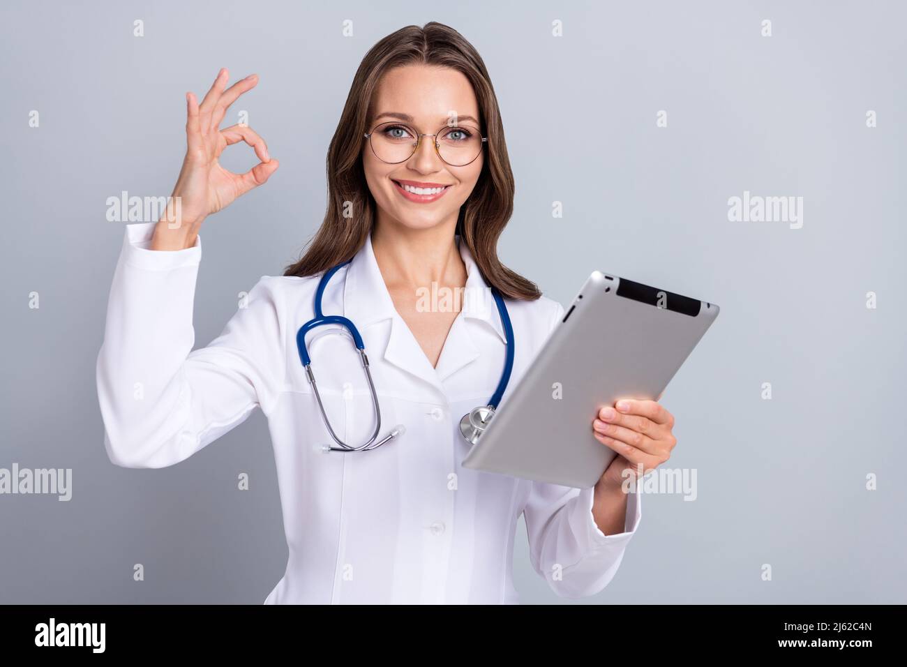 Photo of young woman cardiologist use modern device show fingers okey ...