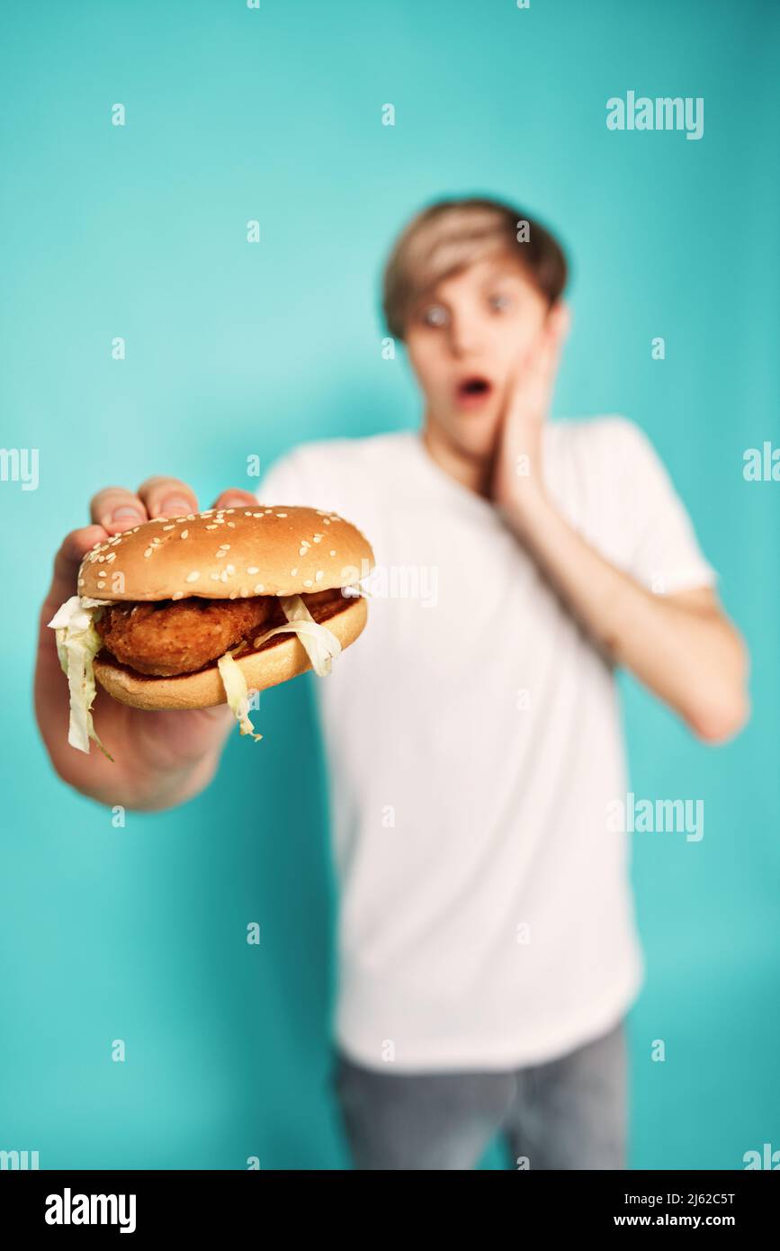 Very hungry young man holding tasty hamburger Stock Photo - Alamy