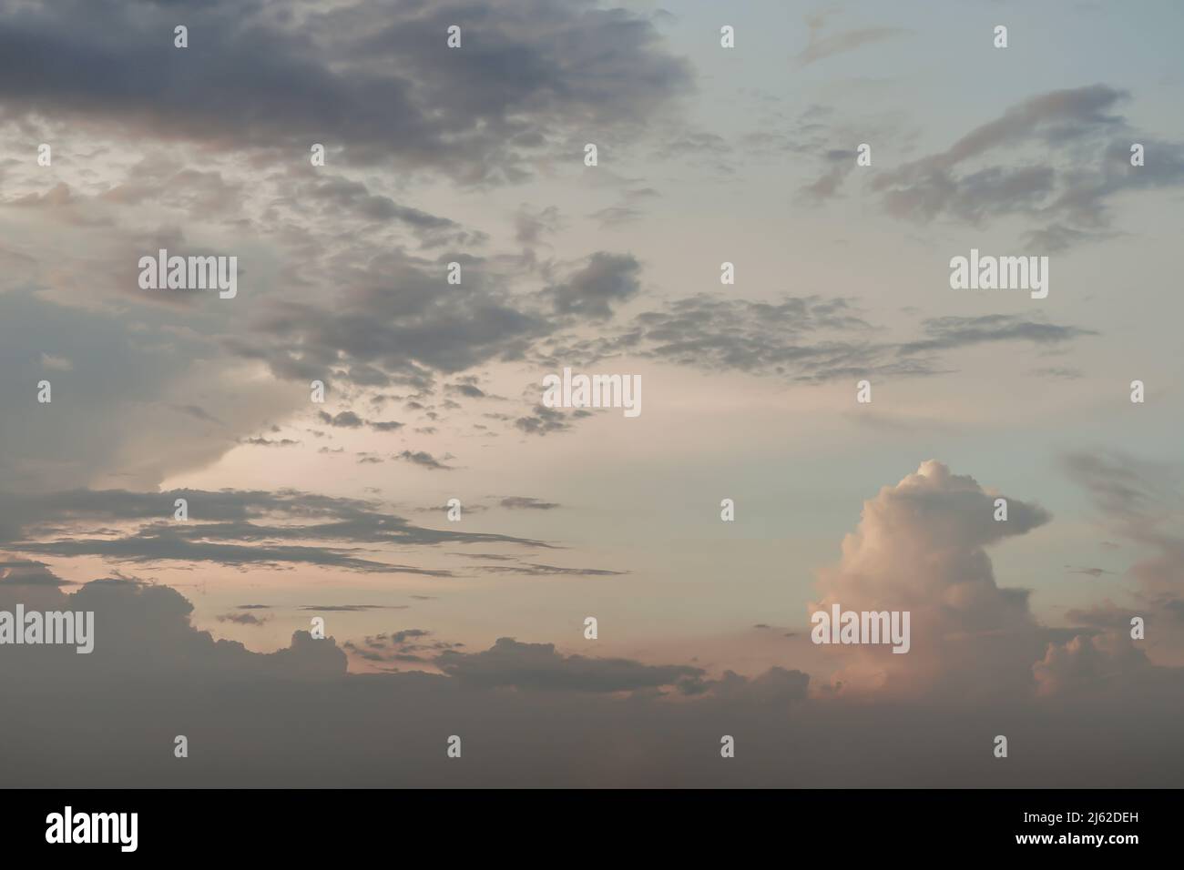 The sun shines through the clouds in the sunset sky with dramatic light ...