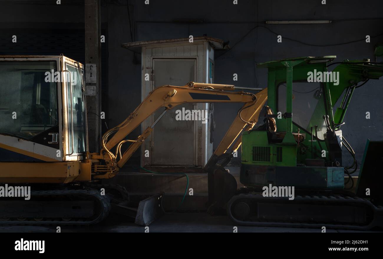 Two construction excavators of yellow and green color for the ...
