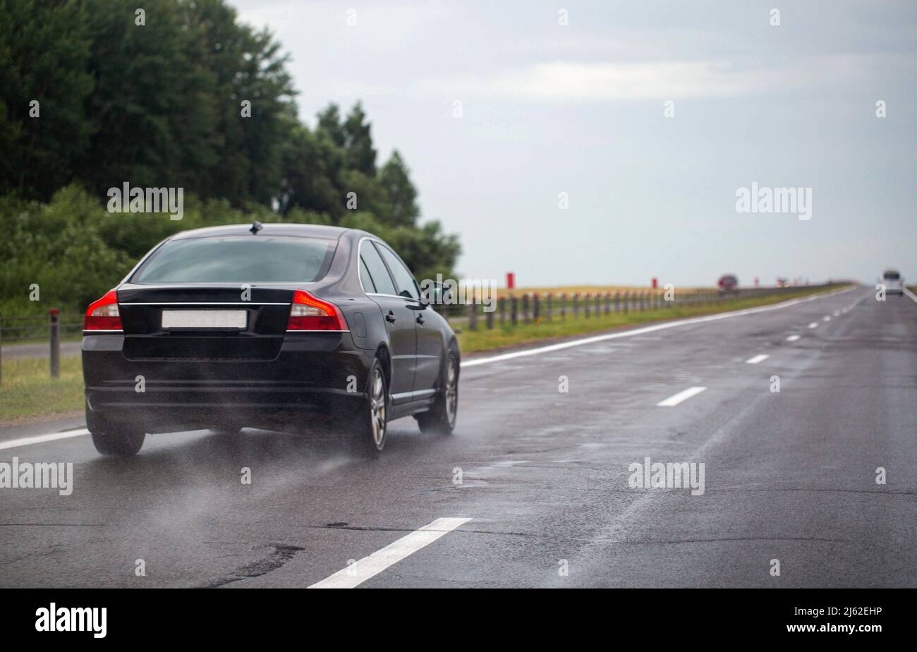 Passenger car driving on a rain wet road hi-res stock photography and ...