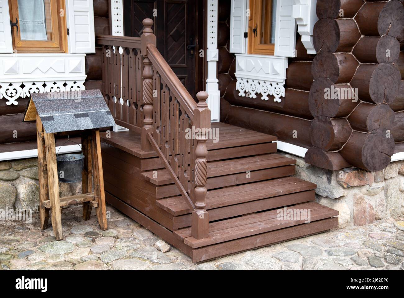 Wooden porch with steps and a door to a log cabin. Village houses ...