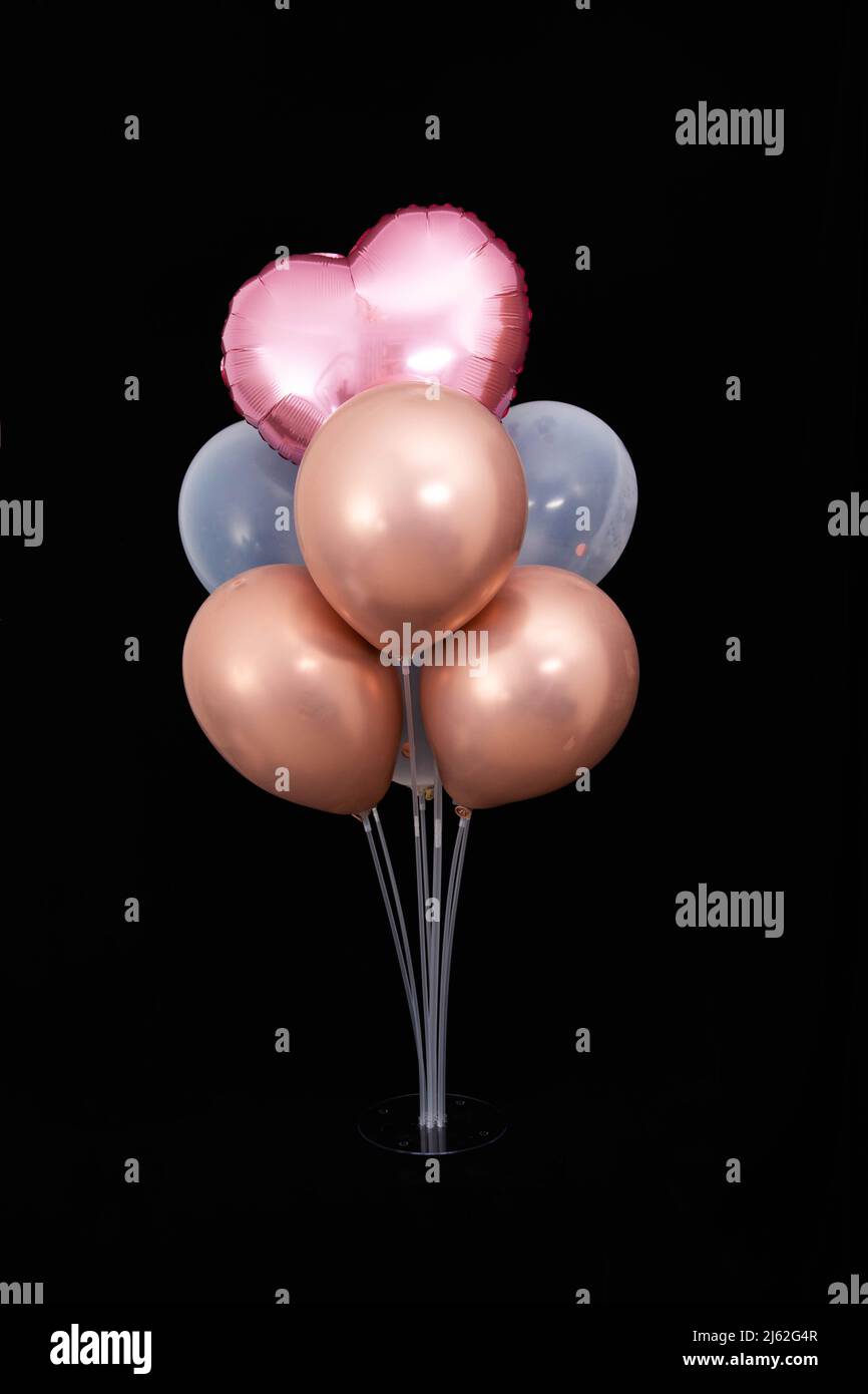 Set of balloons inflated with helium pink and white on a black ...