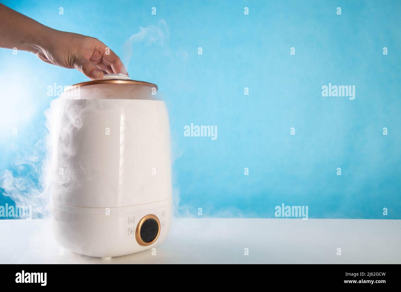 Modern device for air humidification on a blue background. Wet Steam ...