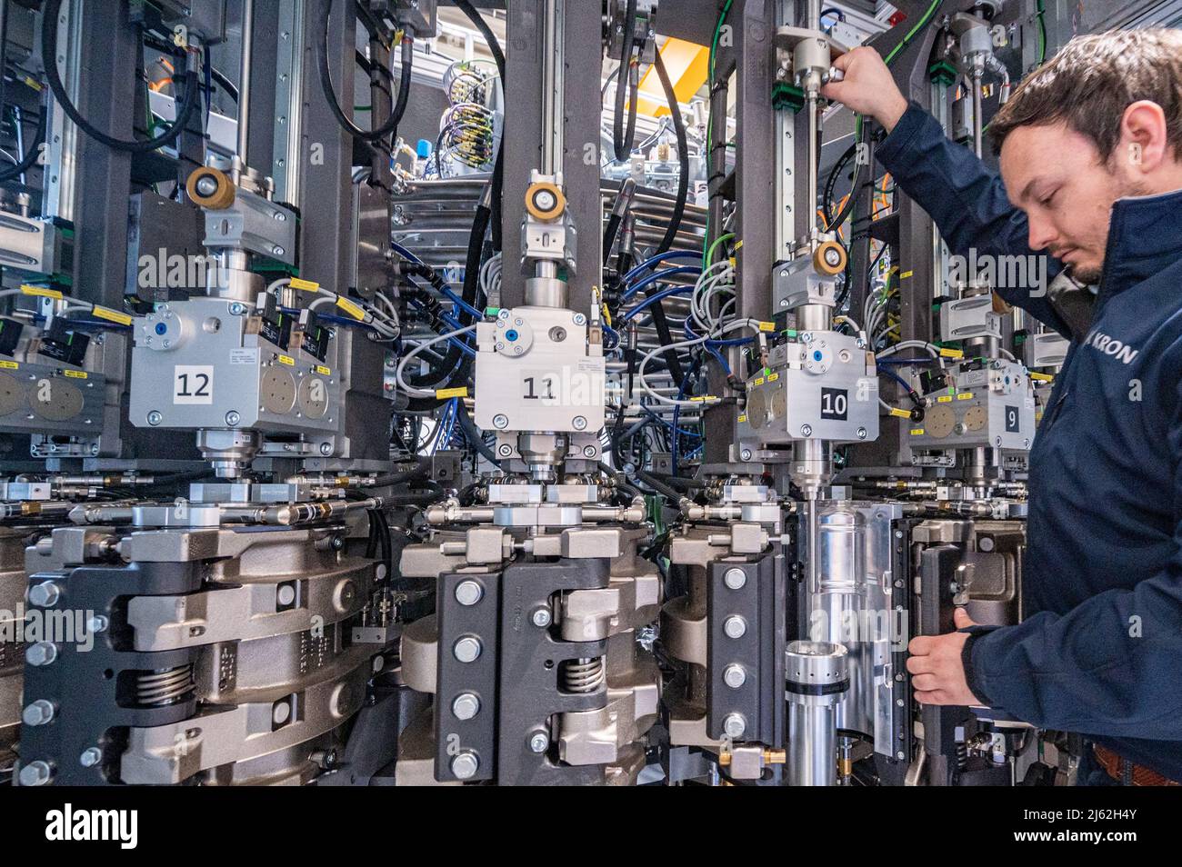 Neutraubling, Germany. 25th Apr, 2022. A Krones AG employee works on a ...