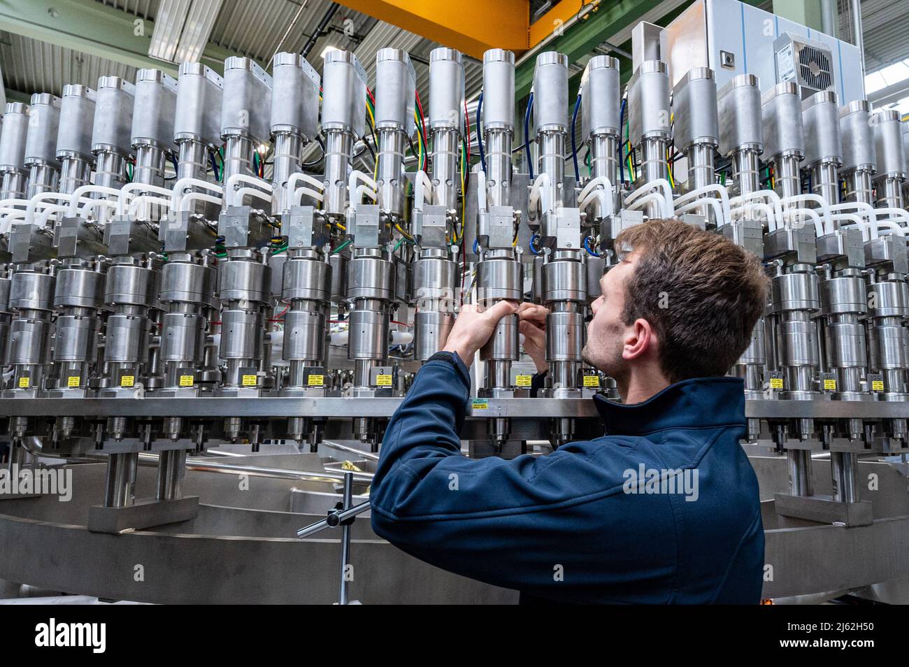 Neutraubling, Germany. 25th Apr, 2022. A Krones AG employee works on a ...