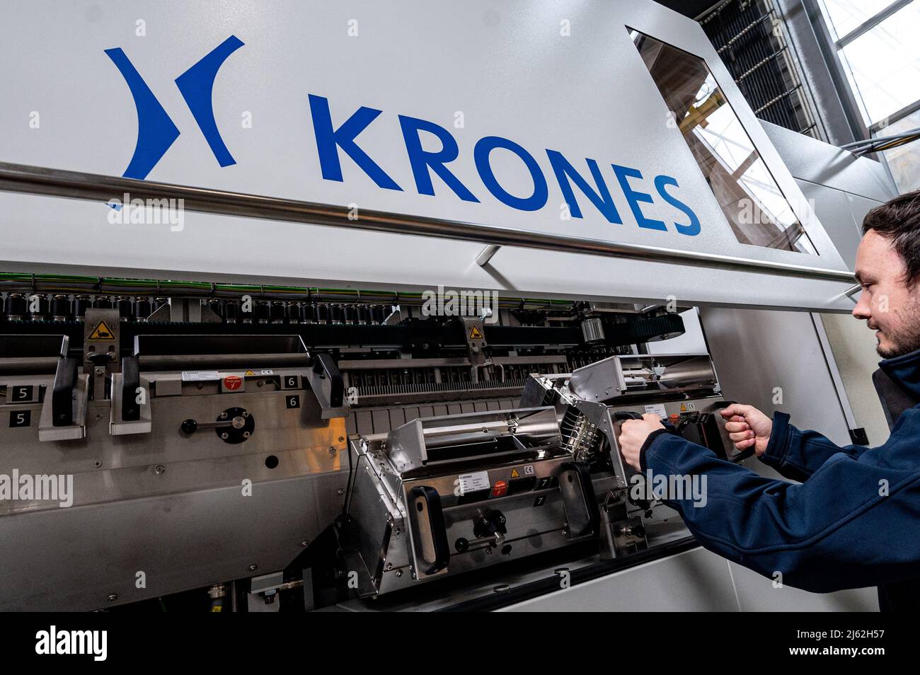 Neutraubling, Germany. 25th Apr, 2022. A Krones AG employee works on a ...