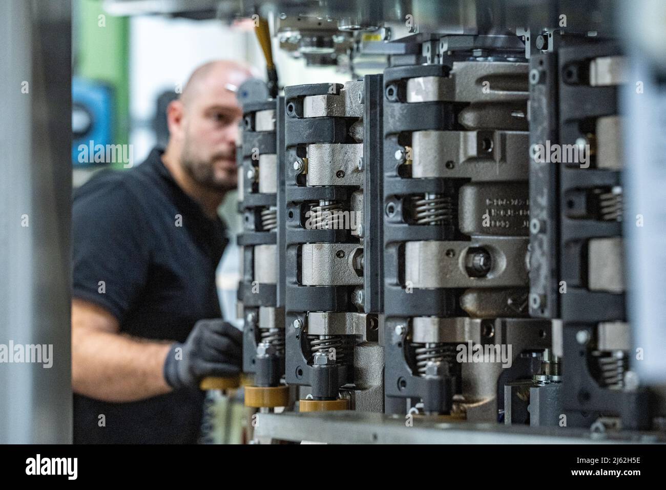 Neutraubling, Germany. 25th Apr, 2022. A Krones AG employee works on a ...