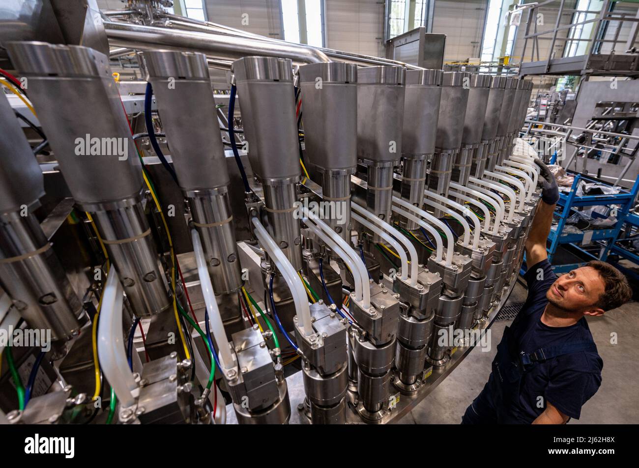 Neutraubling, Germany. 25th Apr, 2022. A Krones AG employee works on a ...