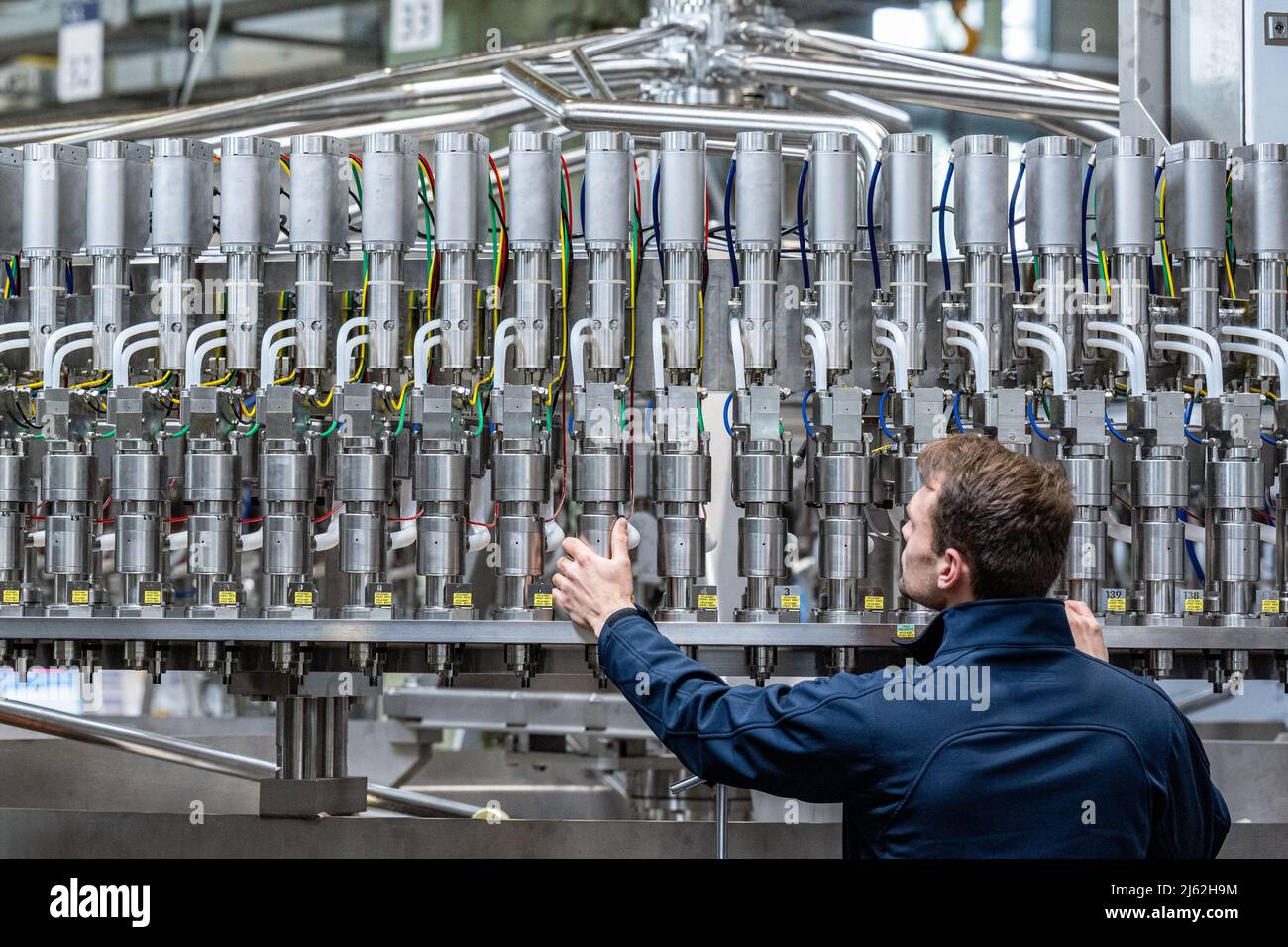 Neutraubling, Germany. 25th Apr, 2022. A Krones AG employee works on a ...