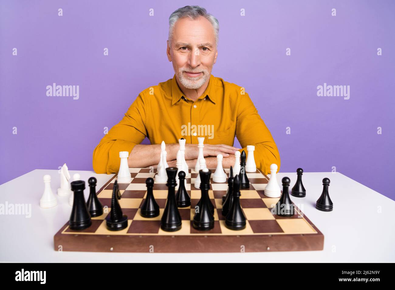 Photo of senior handsome man sit table play chess weekend competition ...