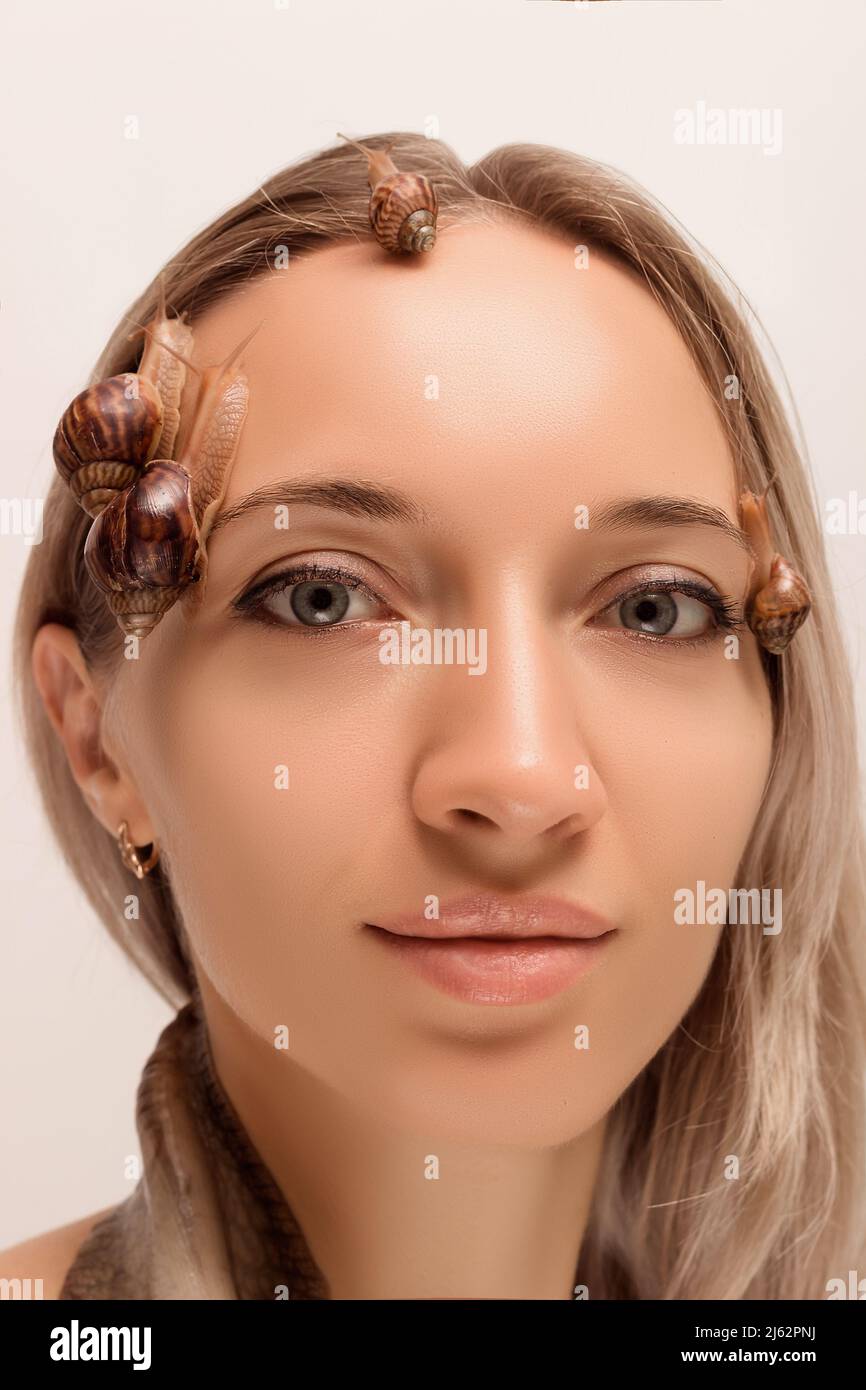 Large and small snails of achatina crawl on the face and neck of a ...