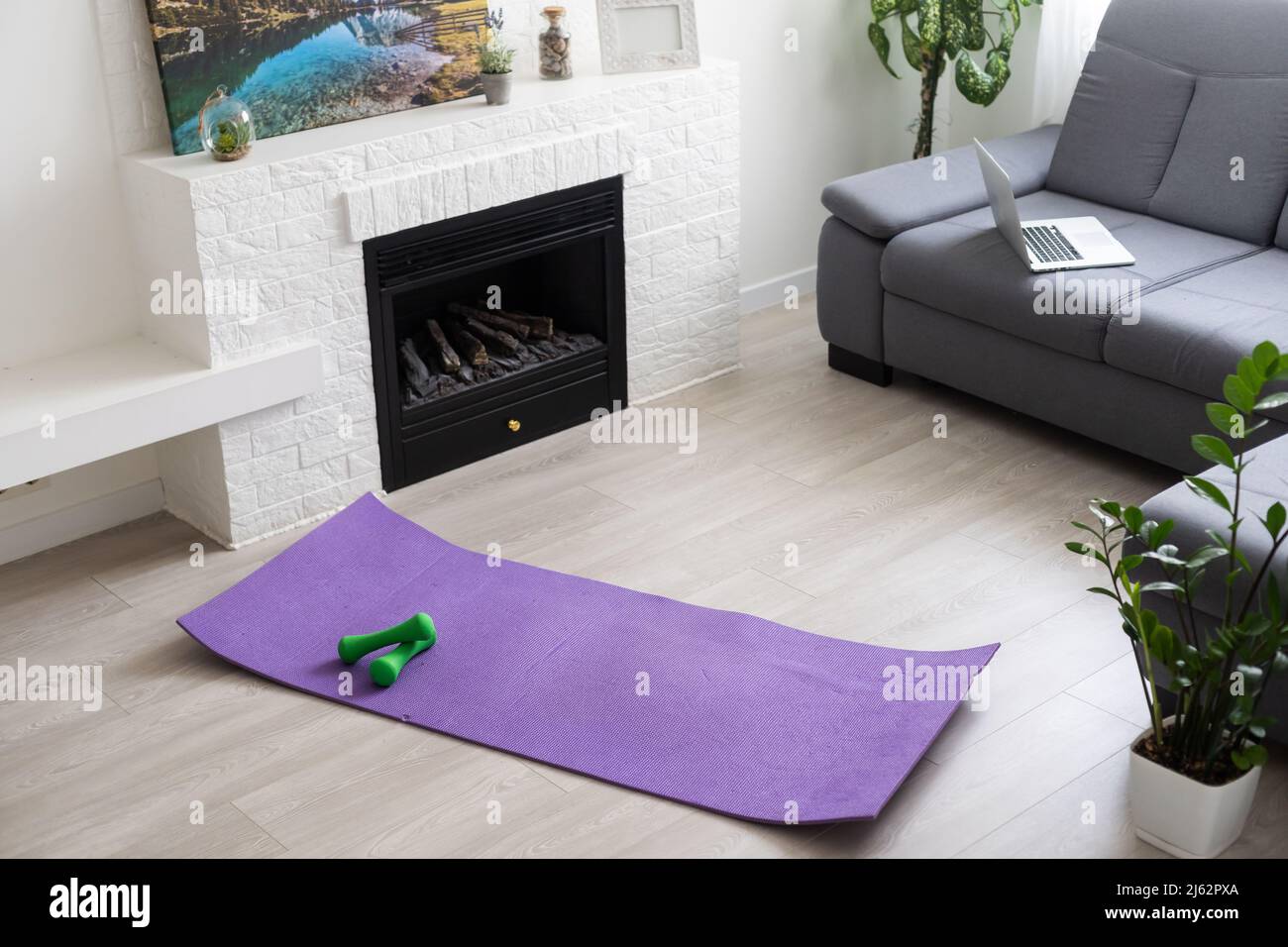 Training at home concept, grey sofa and mat style Stock Photo - Alamy