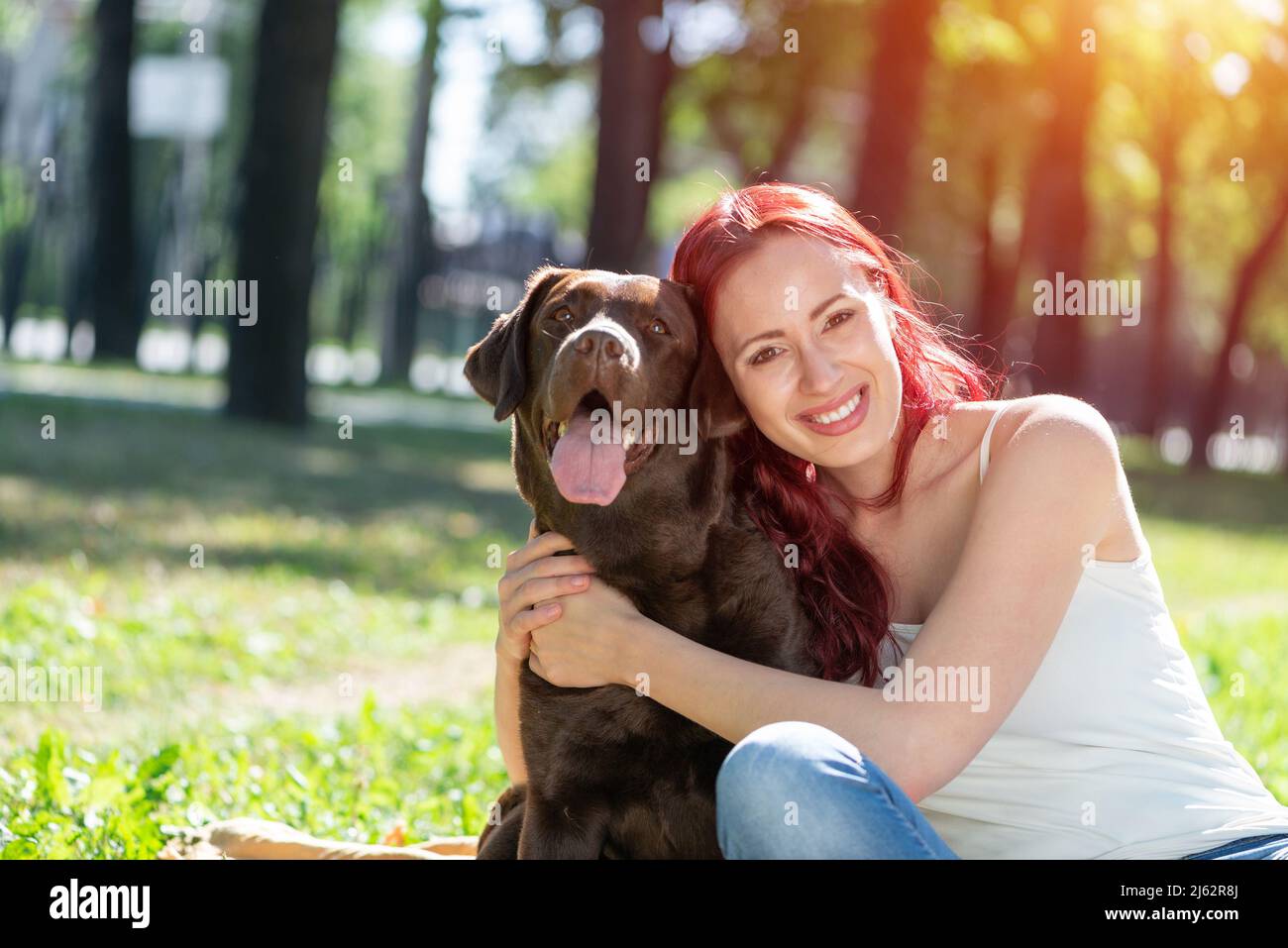 Young attractive woman hugs her dog in the park Stock Photo - Alamy