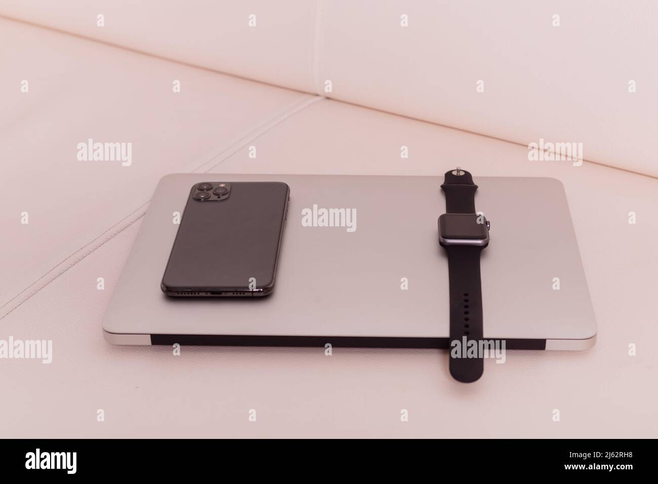 The phone and watch are on top of the laptop Stock Photo - Alamy