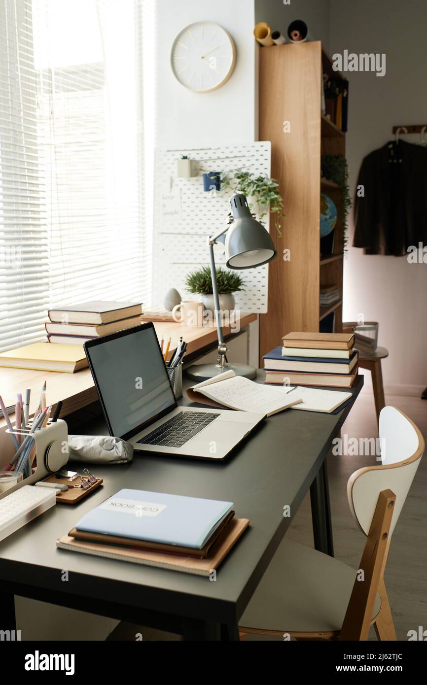 Modern workplace of student consisting of electric lamp, books ...