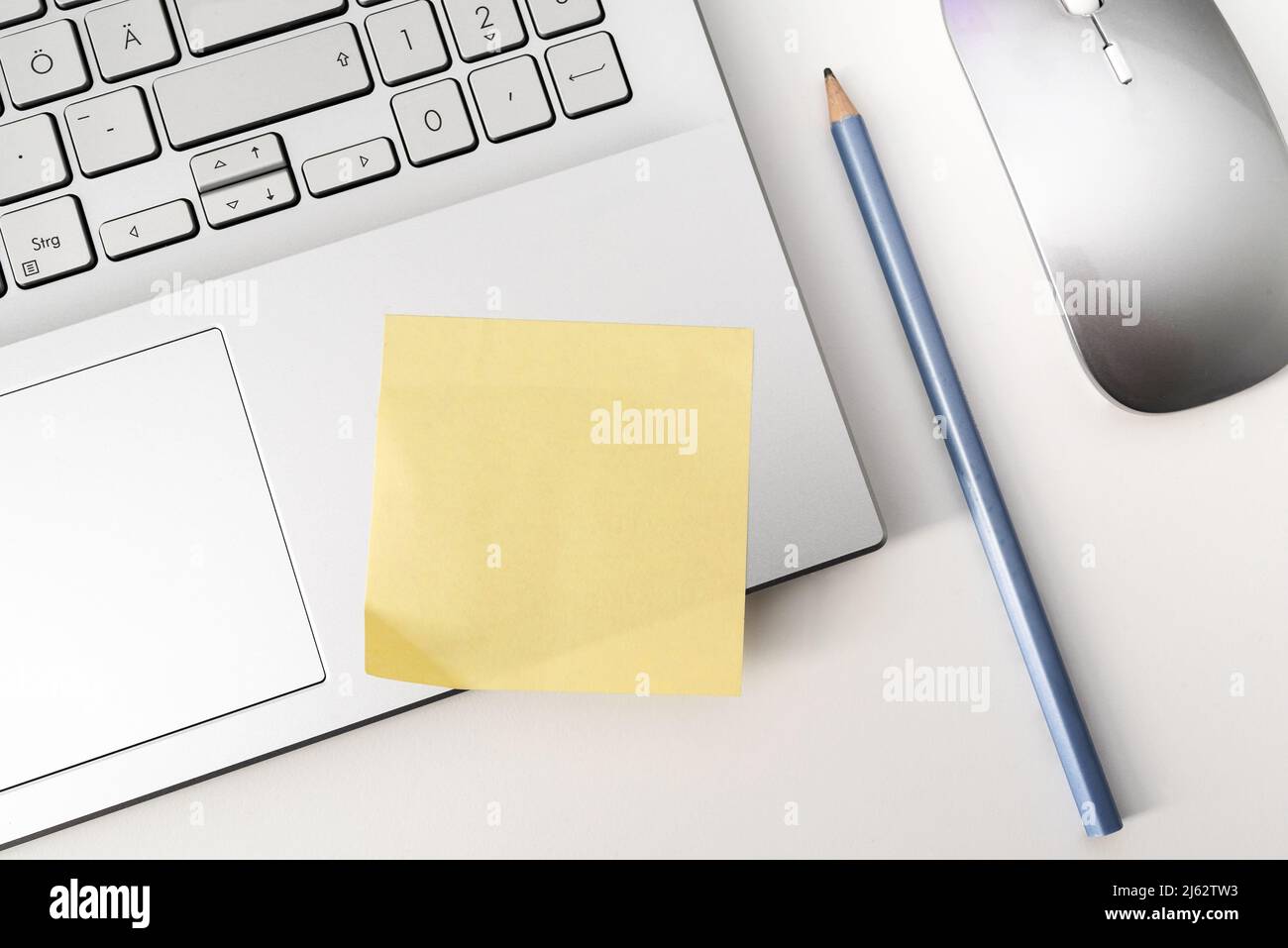 above view of blank yellow sticky note on laptop computer Stock Photo ...