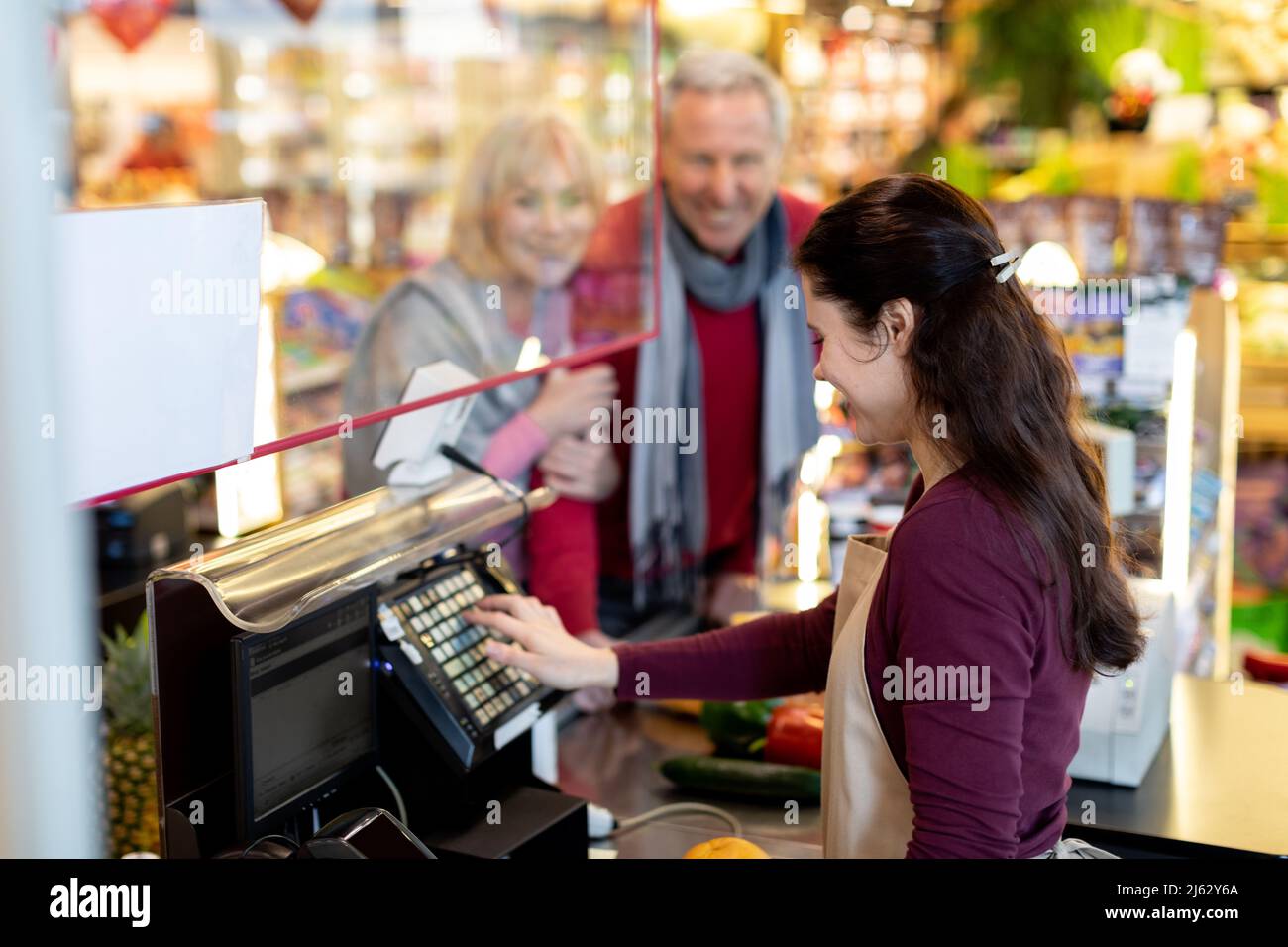 Friendly senior husband and wife having conversation with cashier Stock ...