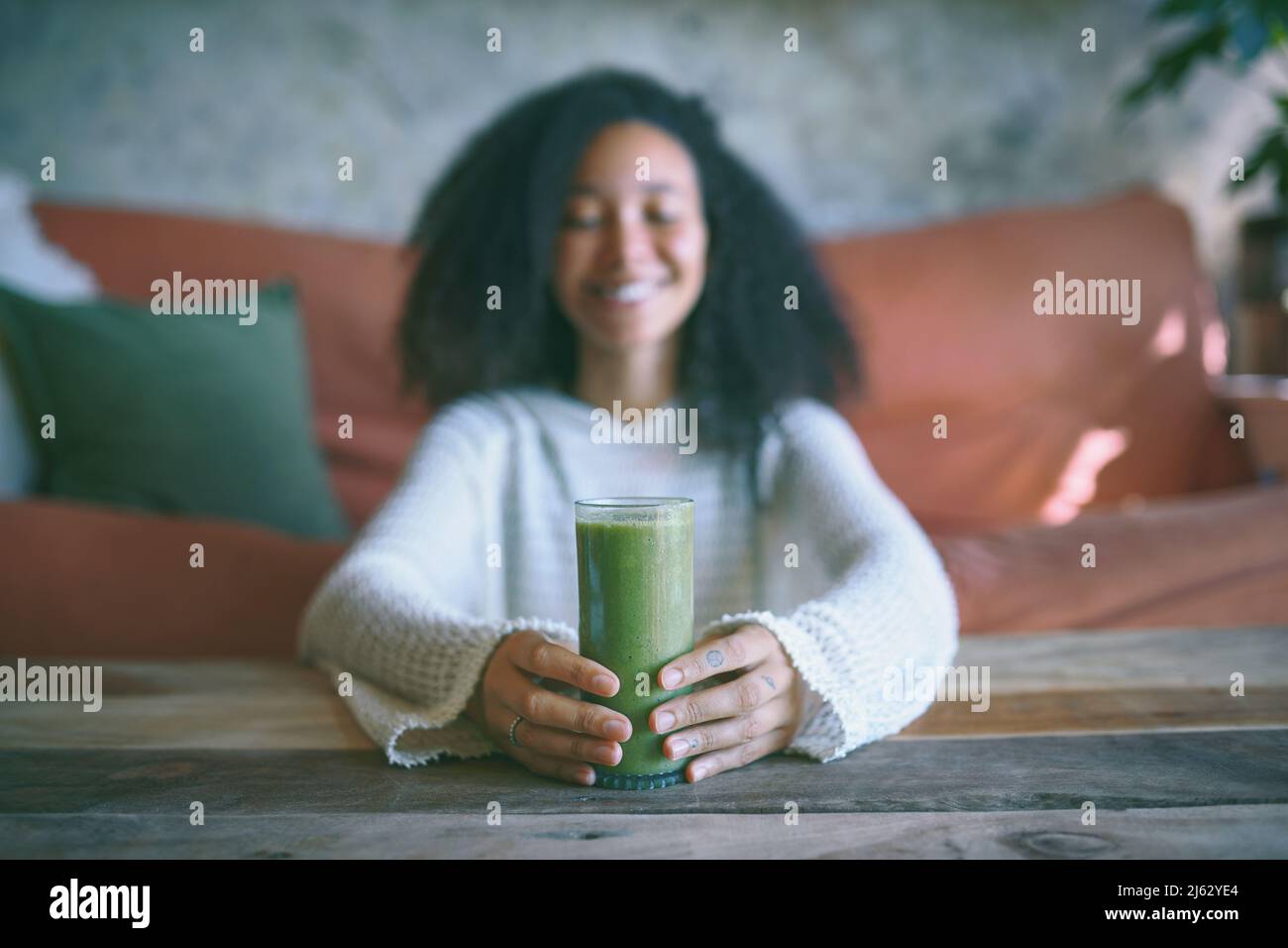 Girl smiling at her green smoothie Stock Photo - Alamy