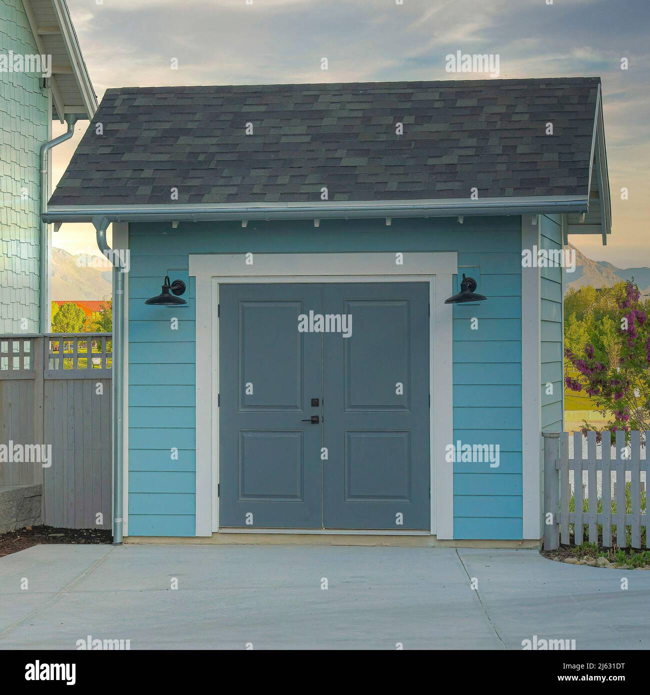 Square Whispy white clouds Light blue storage shed outside a house at ...