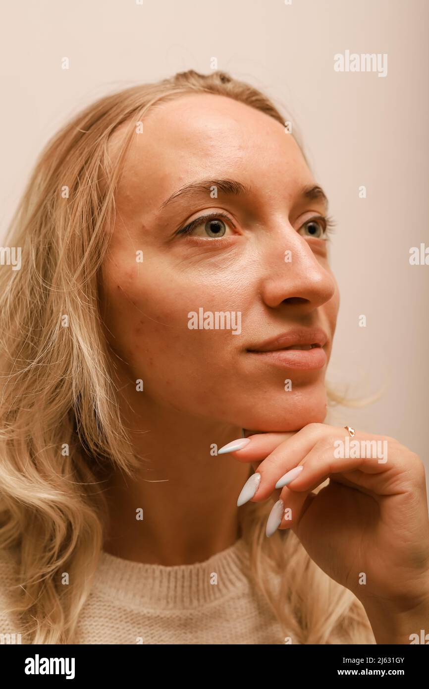 A young woman leaning on her hand smiles Stock Photo - Alamy