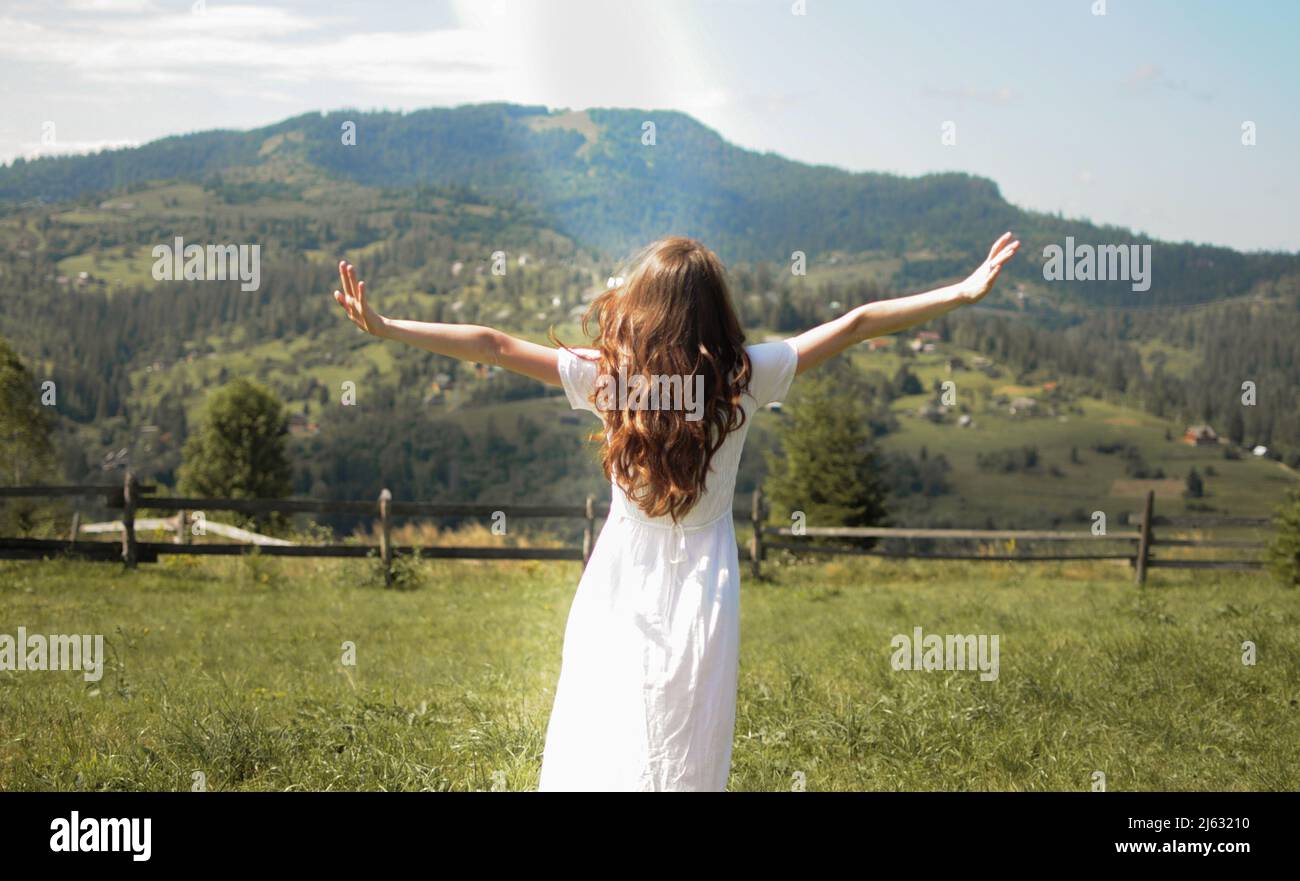 Happy young woman is turning round in the field. Freedom feeling in the ...