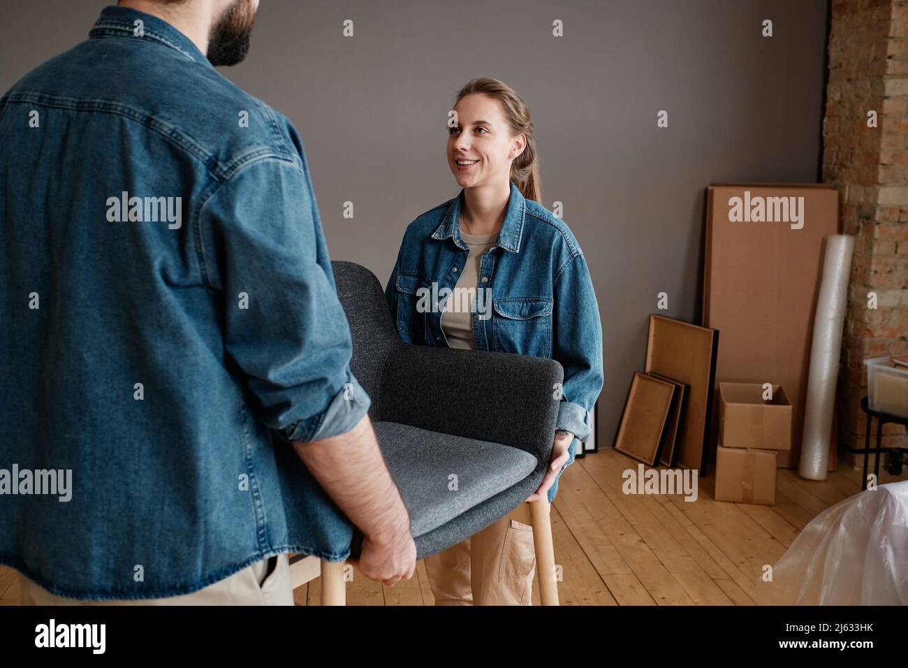 Horizontal shot of modern young man and woman moving to new apartment ...
