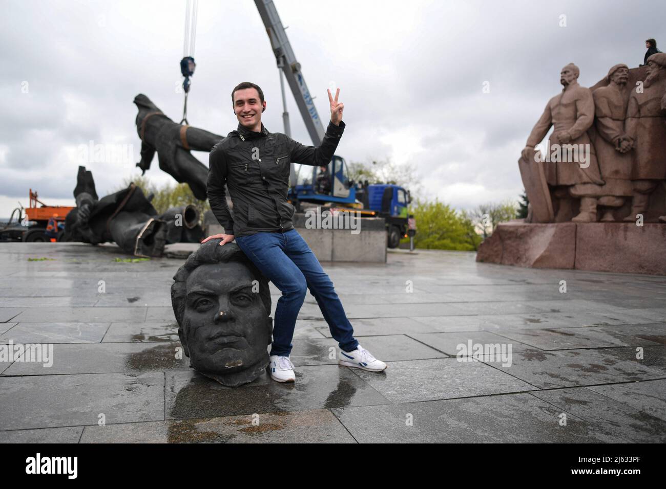 A man poses for photos with the dismantled Soviet Union monument. On ...