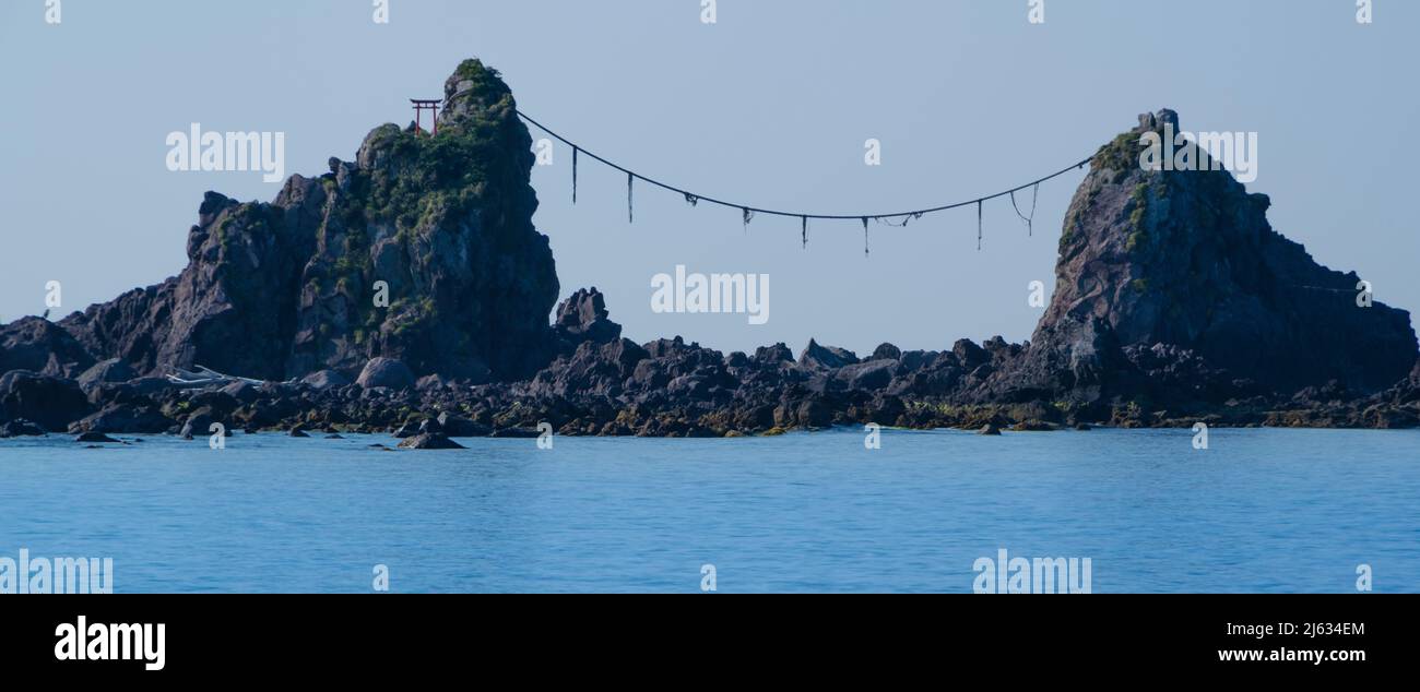 The small torii gate that sits atop the larger rock (left) is mostly ...