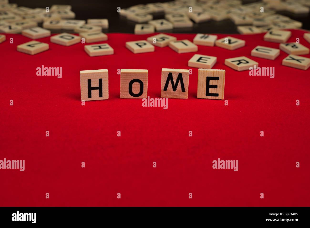 Word "Home" composed of wooden plates with letters on a red felt ...