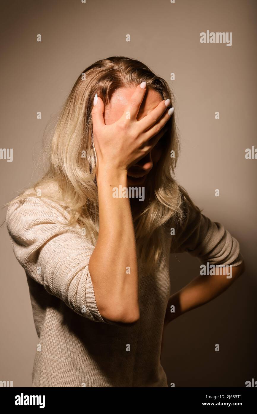 A young woman covering her face in grief lowered her head down Stock ...