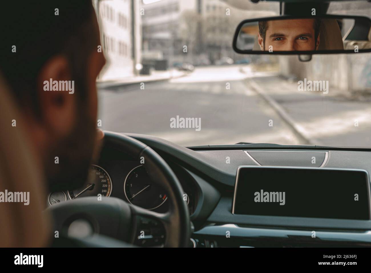 Young elegant male driving a car in the city street Stock Photo - Alamy