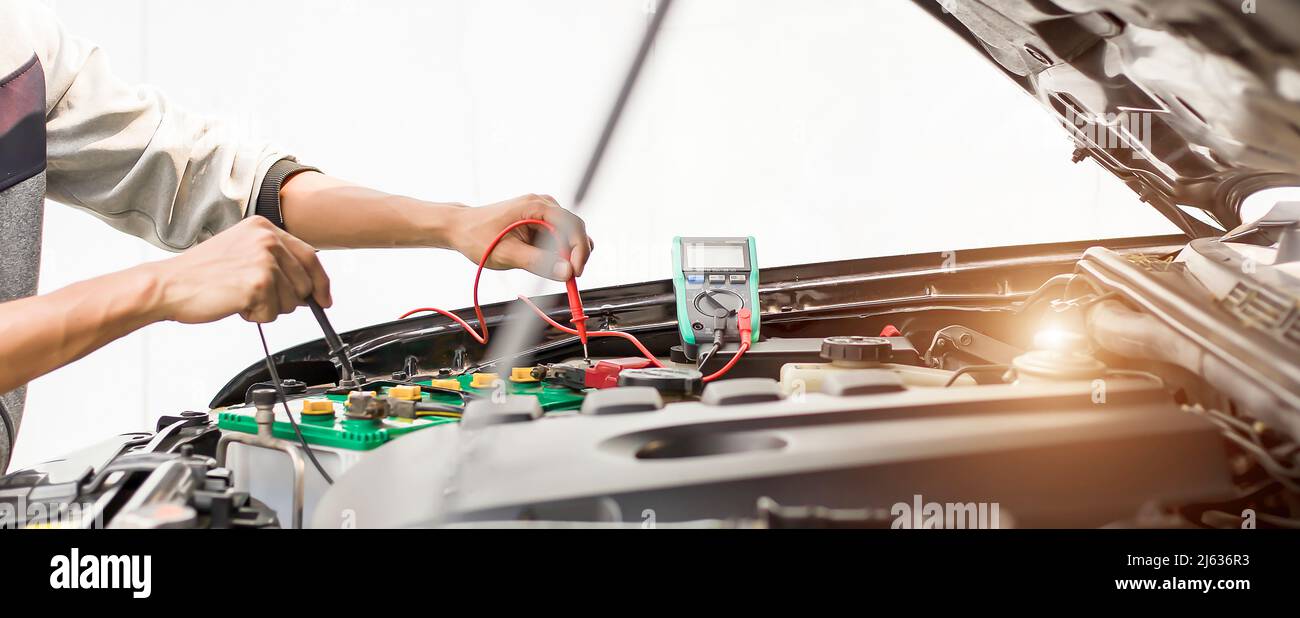 A technician is checking the car battery for availability Stock Photo ...